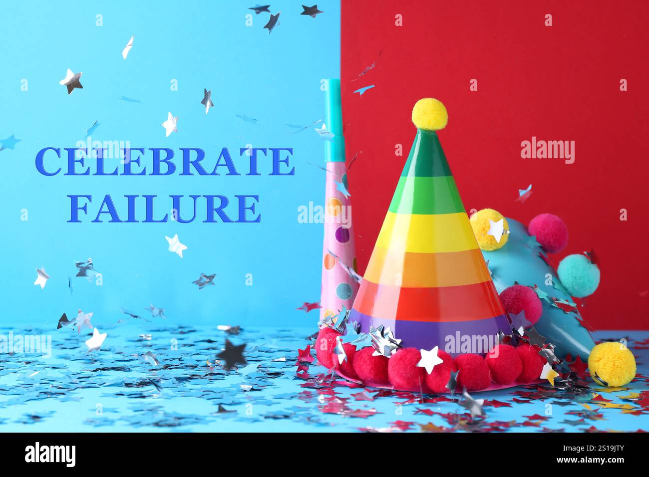 Celebrate failure. Party hats and blower under confetti on light blue ...