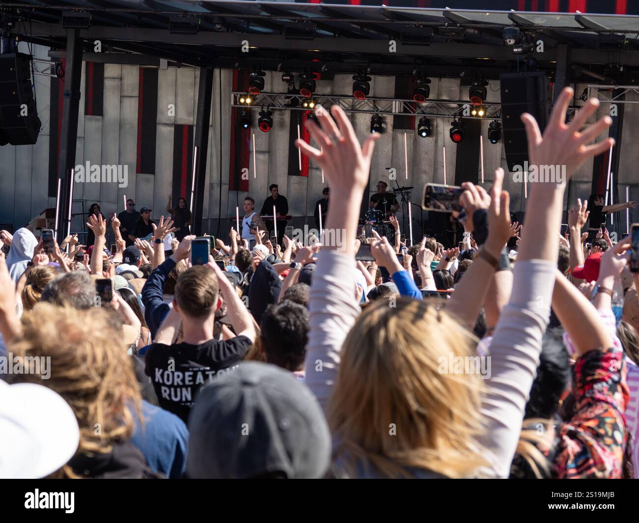 Fans raise their arms cheering for Williams. Robbie Williams performs a ...