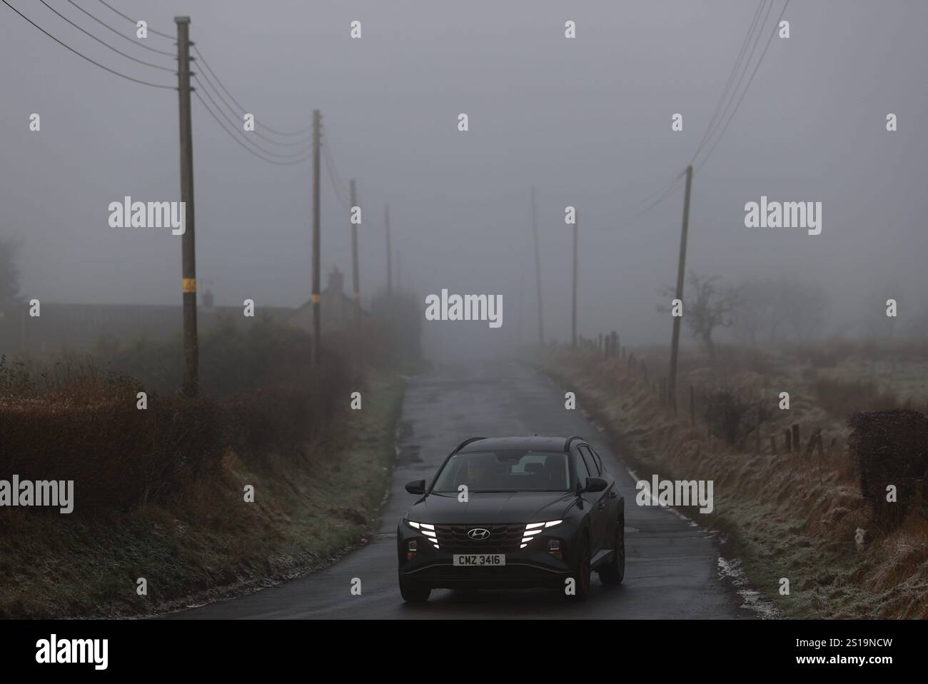 A car drives through thick fog on Tornaroy Road outside Belfast ...
