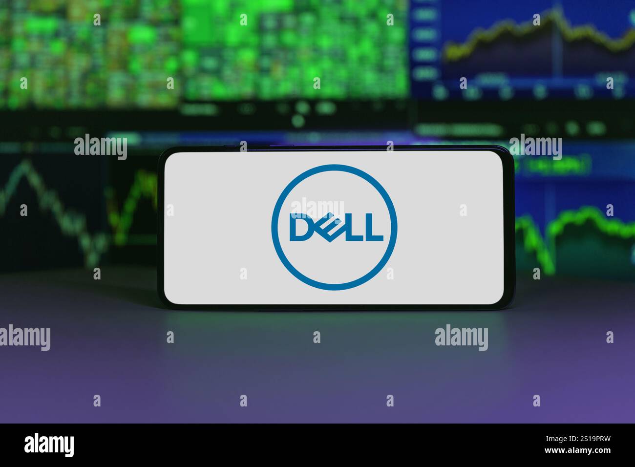 Dell logo displayed on a smartphone screen with stock market charts in ...