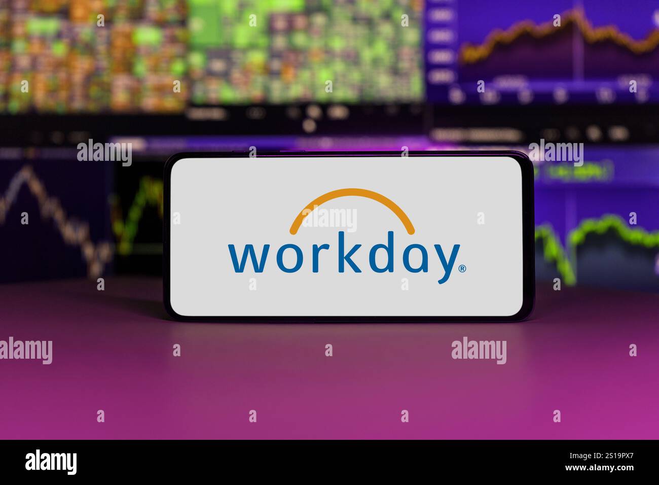 Workday logo displayed on a smartphone screen with stock market charts ...