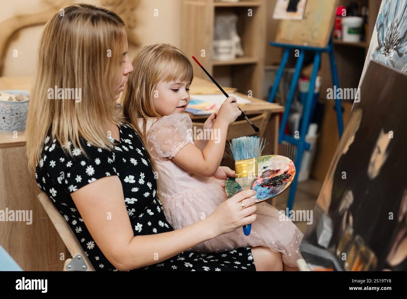 Mother and daughter engage in painting art lesson at a creative studio ...