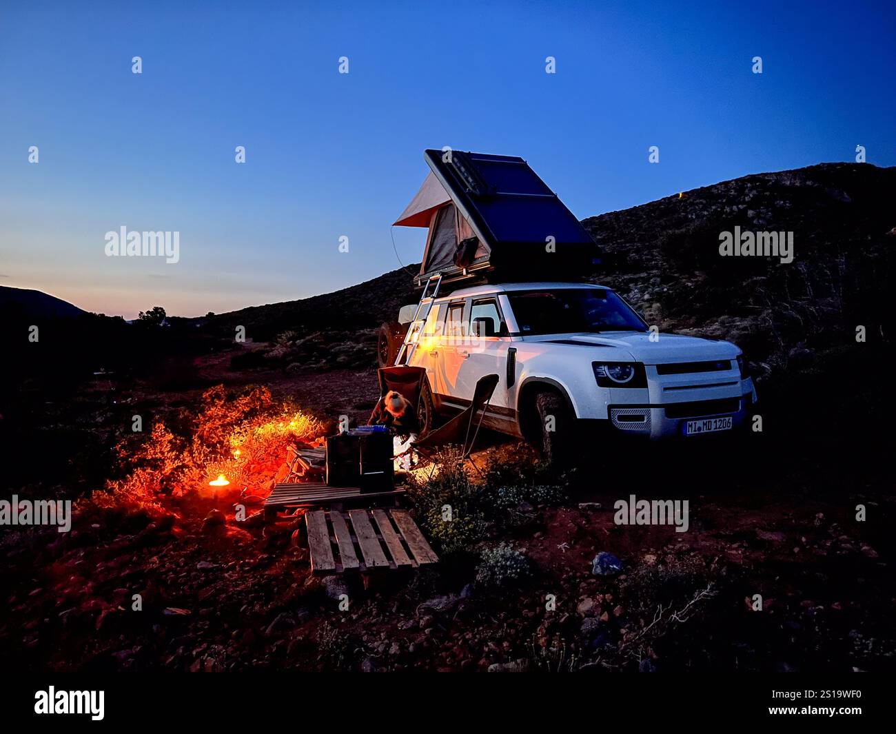 Camping and campfire with an off-road vehicle and roof tent in the ...