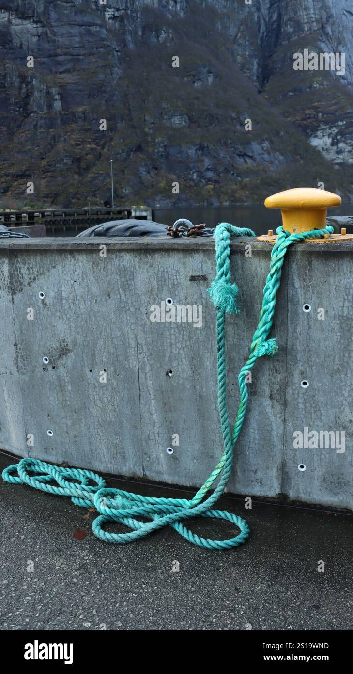 A yellow boat mooring with a turquoise rope falling down a wall in a ...