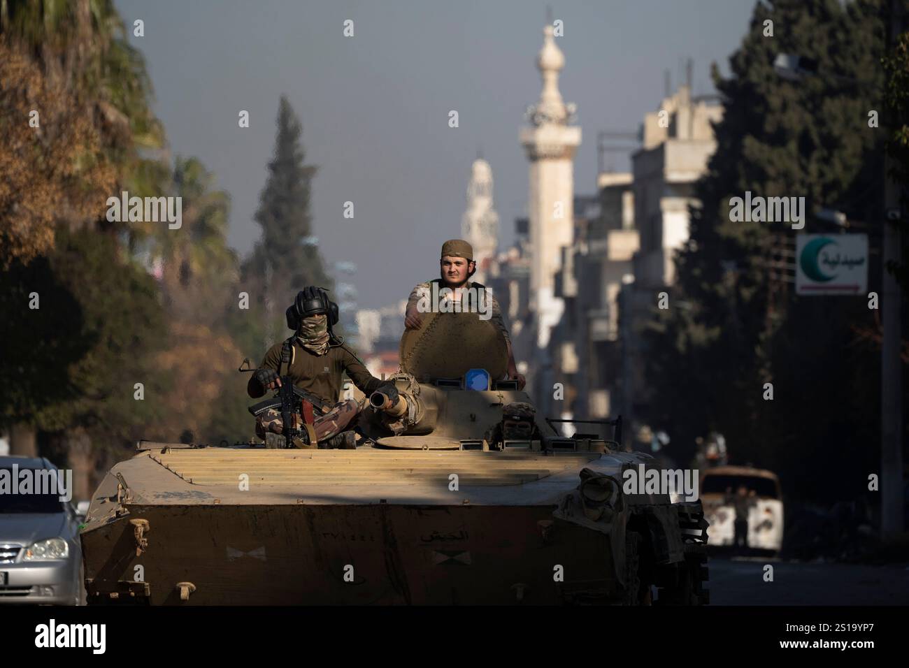 Members of the new security forces move on the top of a tank during an ...