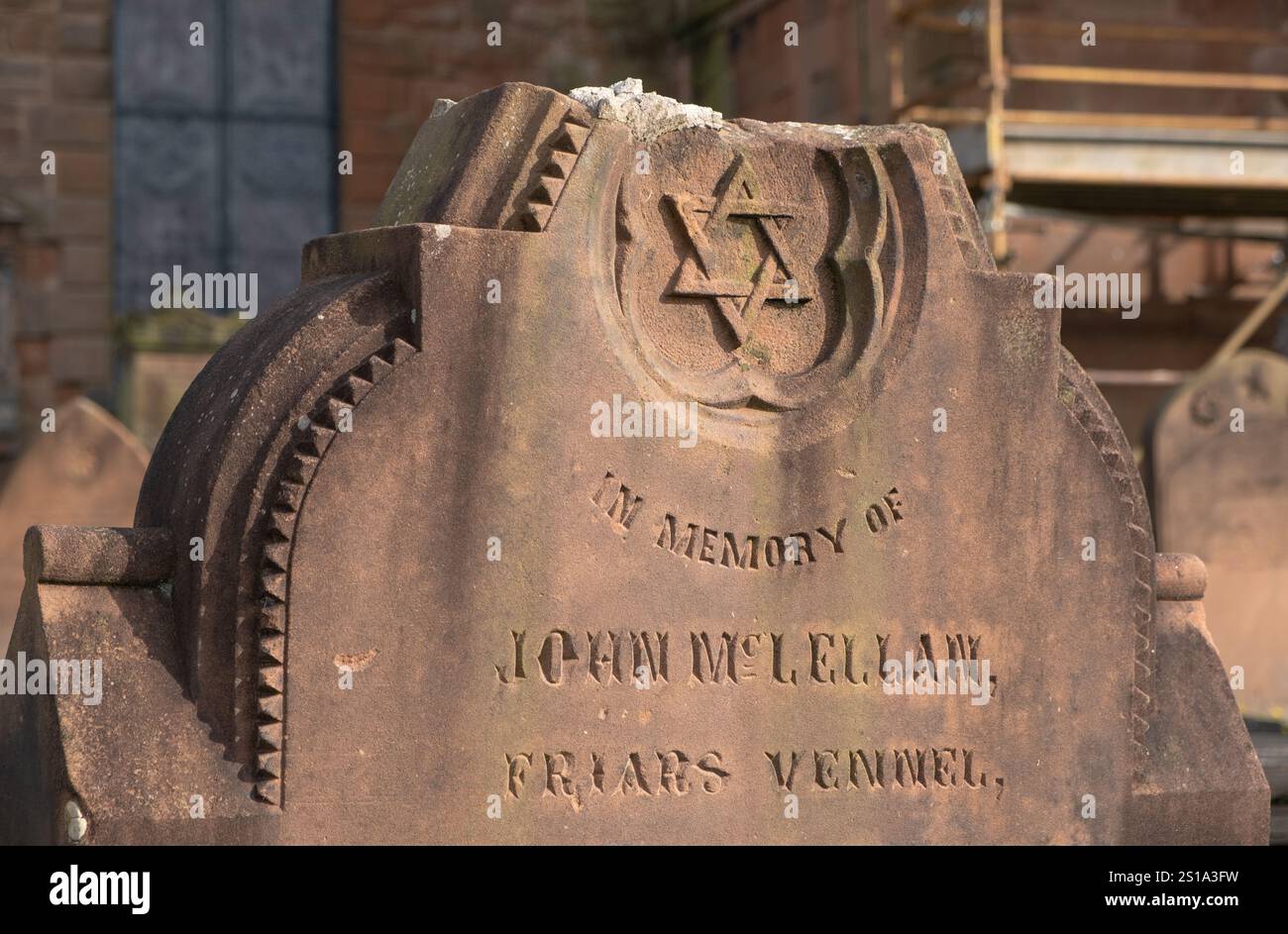 A gravestone with a star shaped symbol, which shows signs of non recent ...