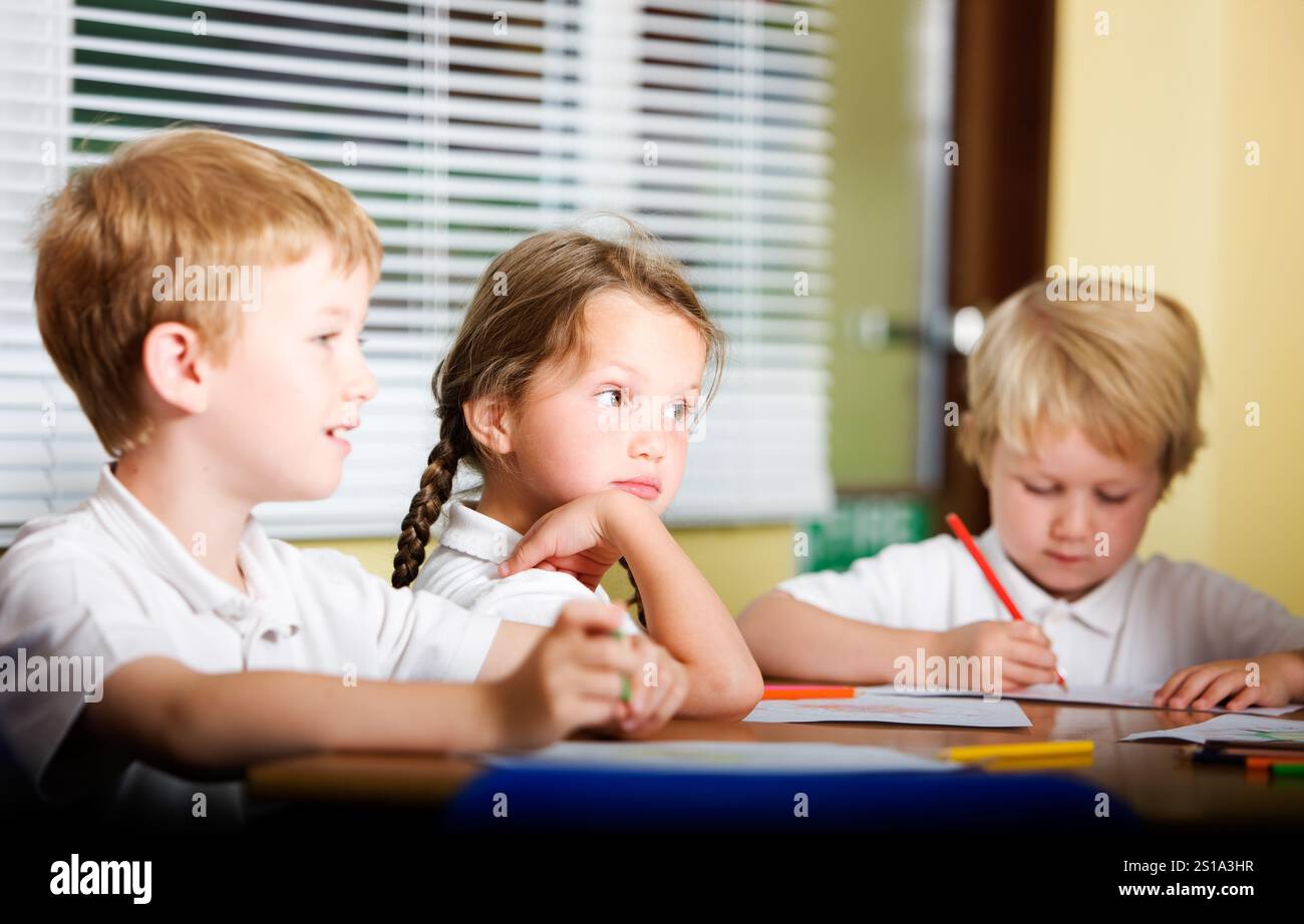 Elementary School: Listening to Teacher. A young school girl with an ...