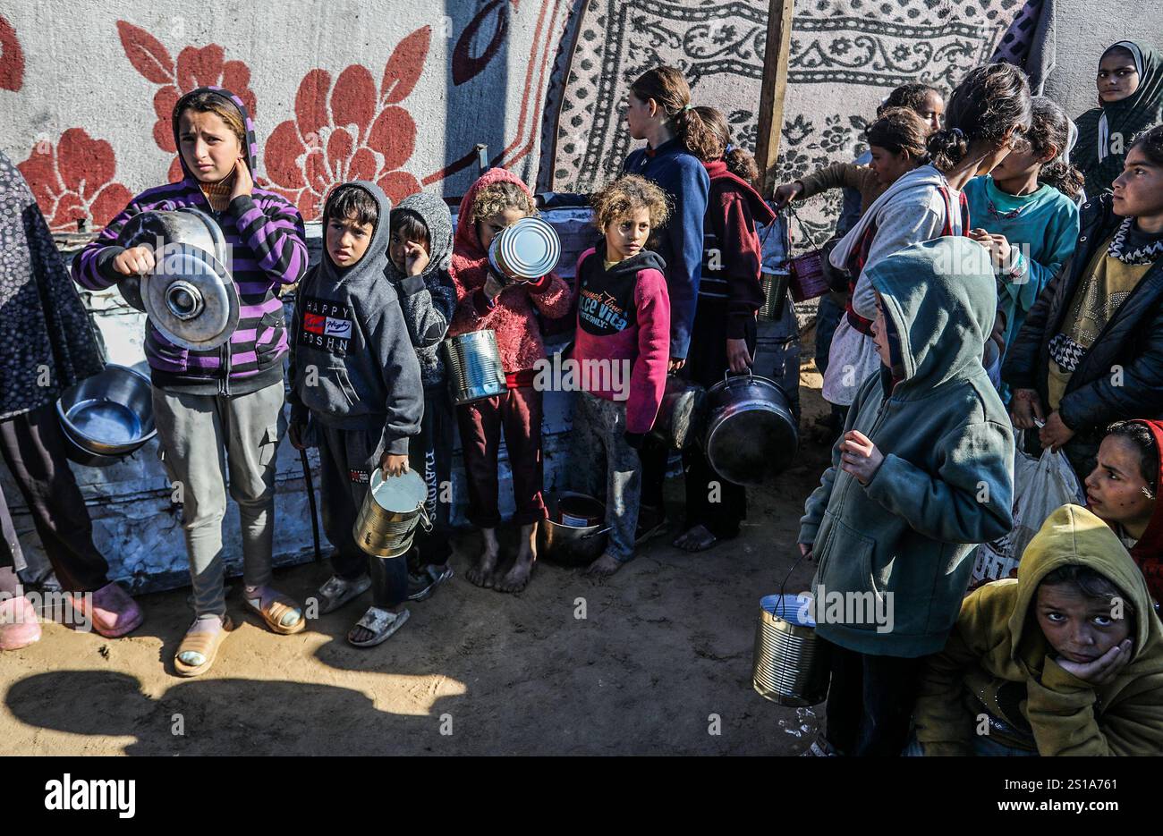 02 January 2025, Palestinian Territories, Rafah: People gather to ...