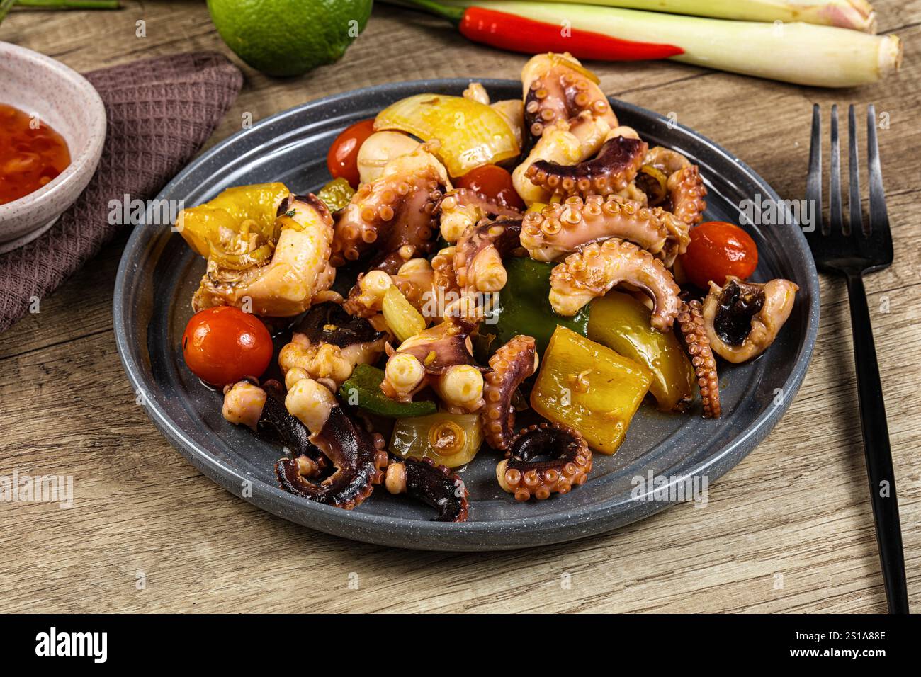 Roasted octopus with vegetables, spices and oil Stock Photo - Alamy
