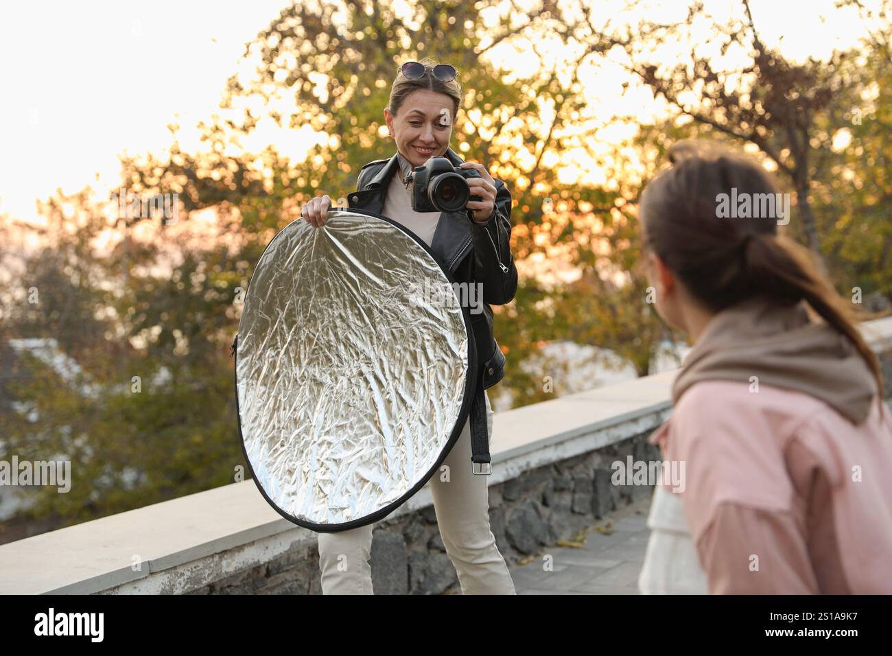 Professional photographers with reflector and camera outdoors Stock ...