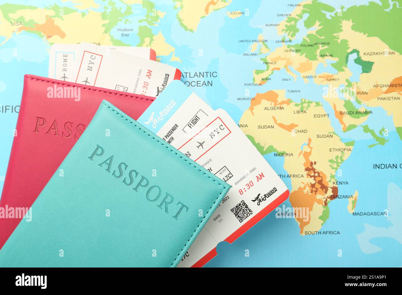 Passports in color covers and flight tickets on world map, top view ...