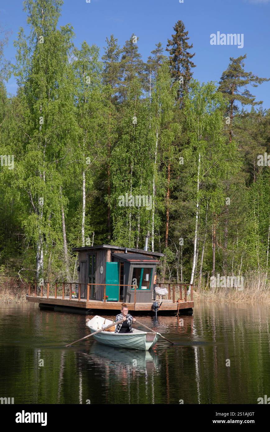 Finland, Lake district, lac Saimaa, Finnish woman rowing her boat in ...
