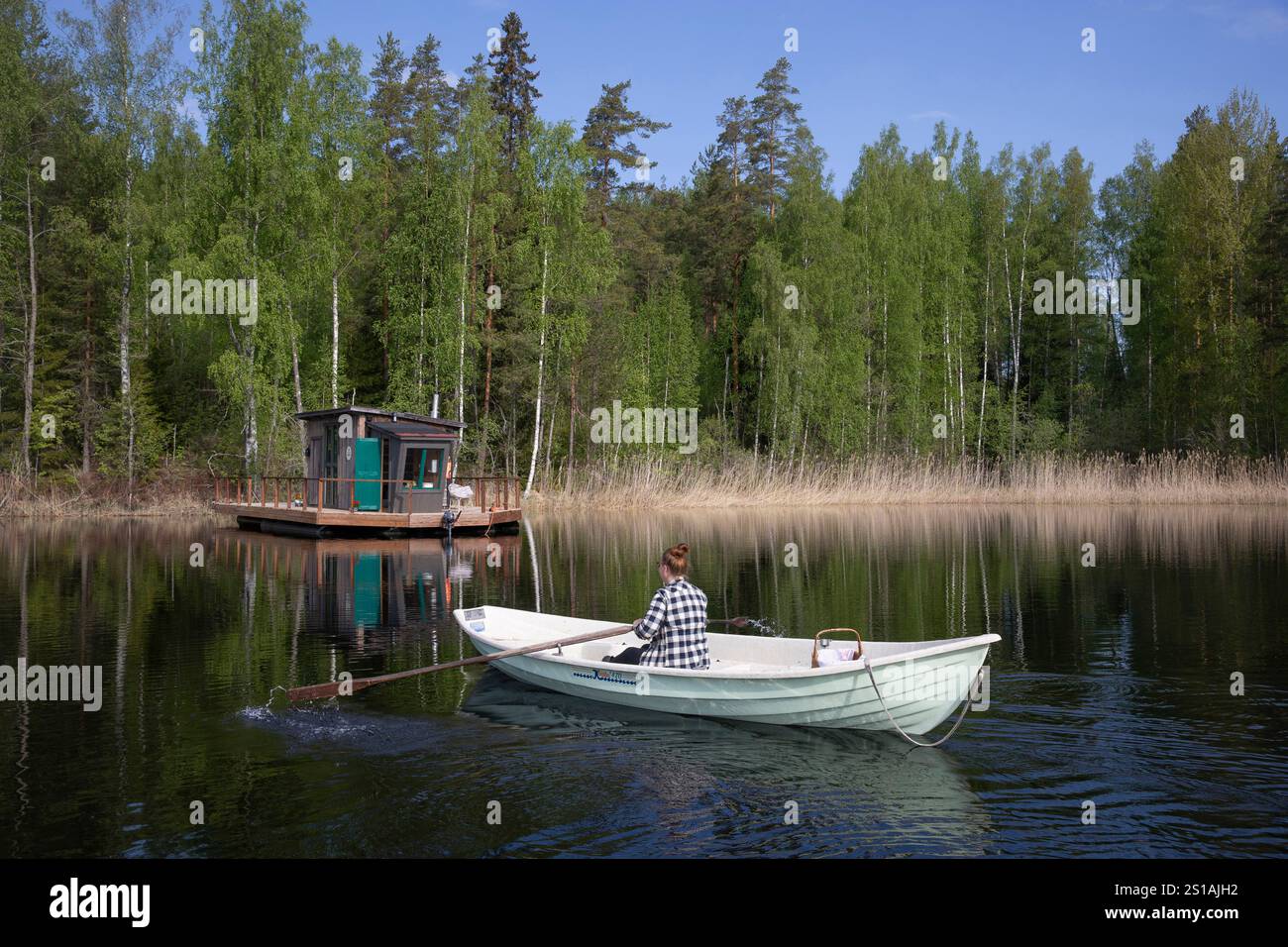 Finland, Lake district, lac Saimaa, Finnish woman rowing her boat in ...