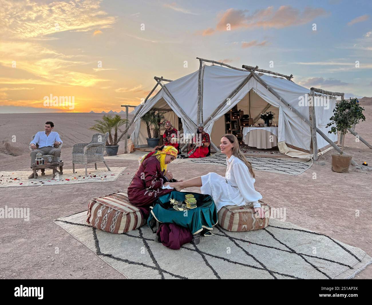 Morocco; Marrakeck, Agafay, young woman getting a henna tattoo from a ...