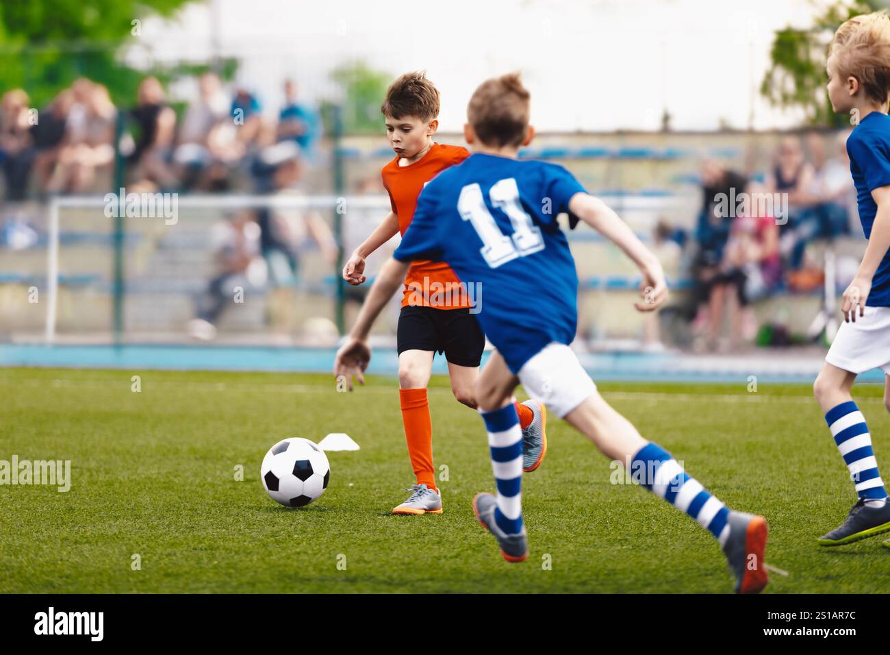 Children playing football. Kids play soccer on an outdoor pitch. Little ...