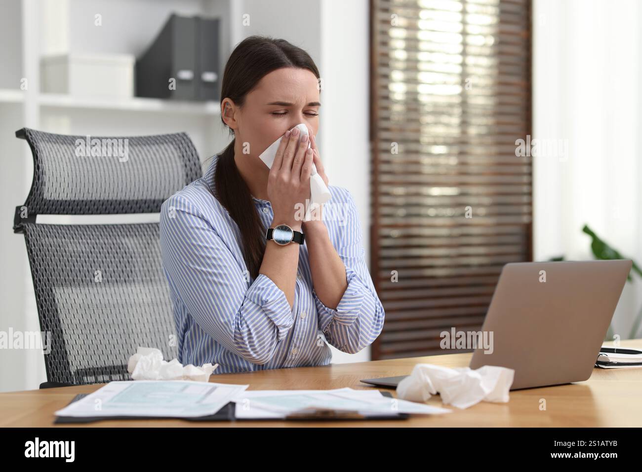Sick woman with runny nose at table in office Stock Photo - Alamy