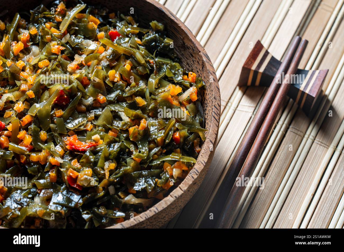 Healthy and fresh seaweed salad with carrot and pepper in wooden plate ...