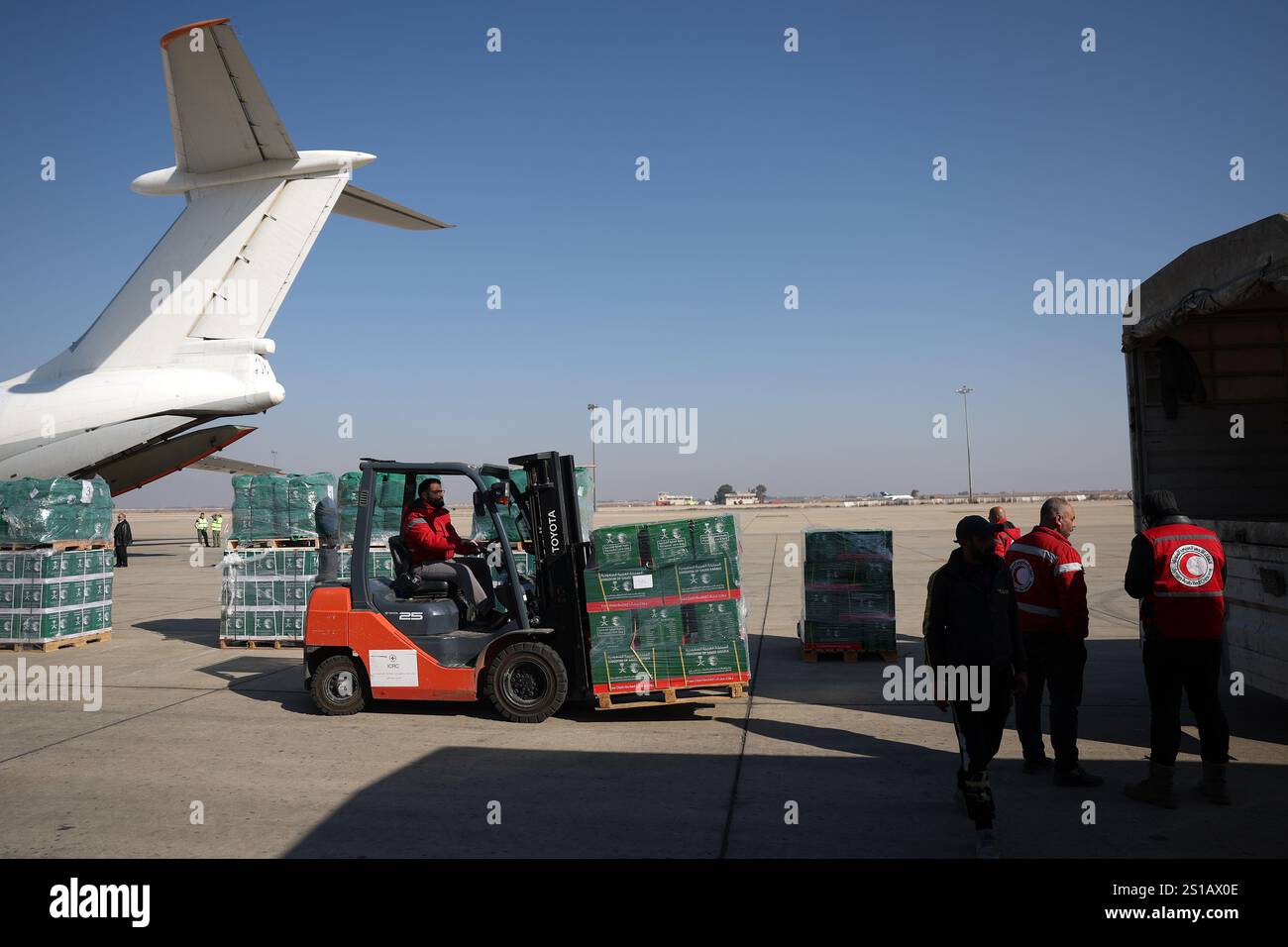 Workers unload humanitarian aid, from Saudi Arabia plane at Damascus International Airport in ...