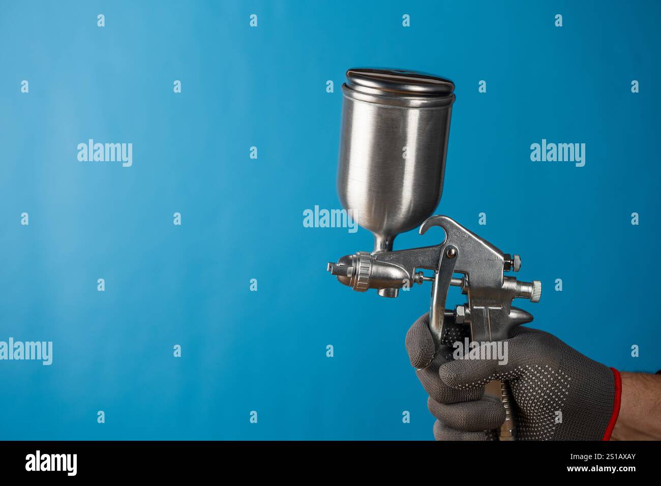Painter hand in glove holding an Industrial size airless spray gun used ...