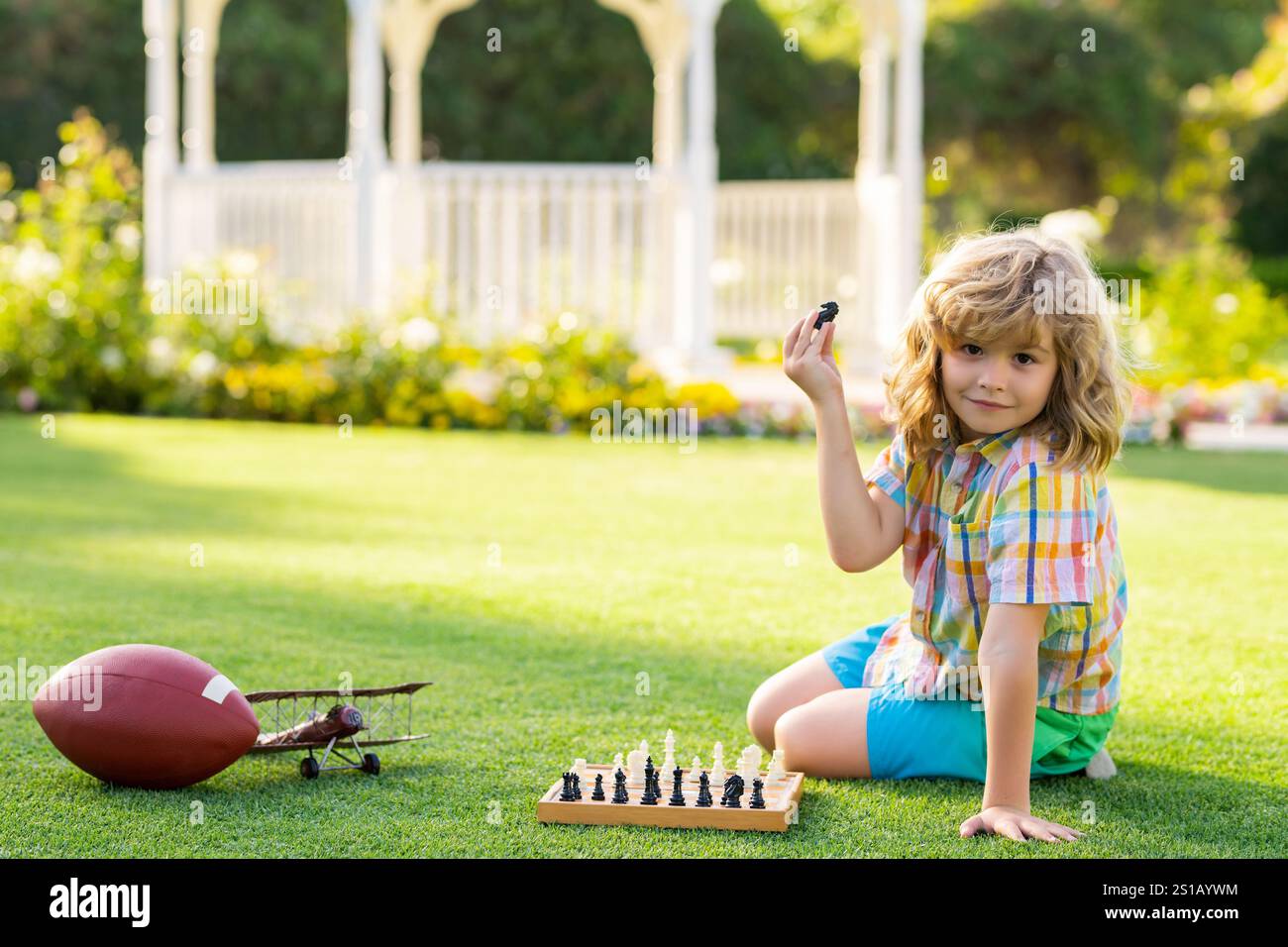 Dream kids and childhood concept. Kid shows chess pieces on a ...