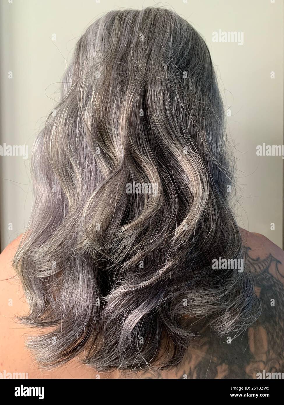 Dark man on his back showing his log grey, thick and wavy hair Stock ...