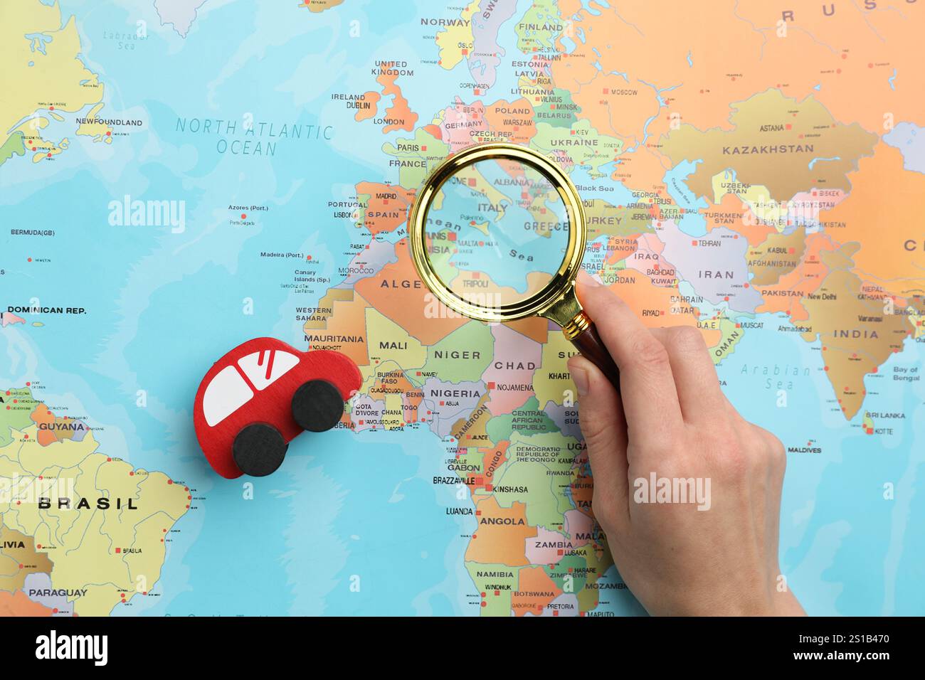 Woman looking at world map through magnifying glass, top view. Road ...