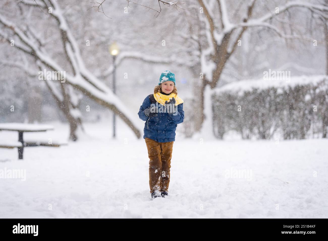 Child playing with snow, outdoors during snowfall. Winter child ...