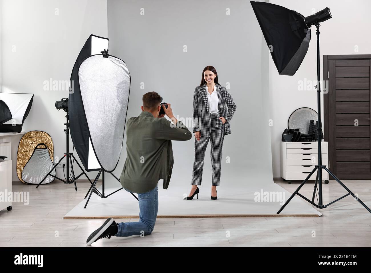 Photographer working with model in professional photo studio Stock ...