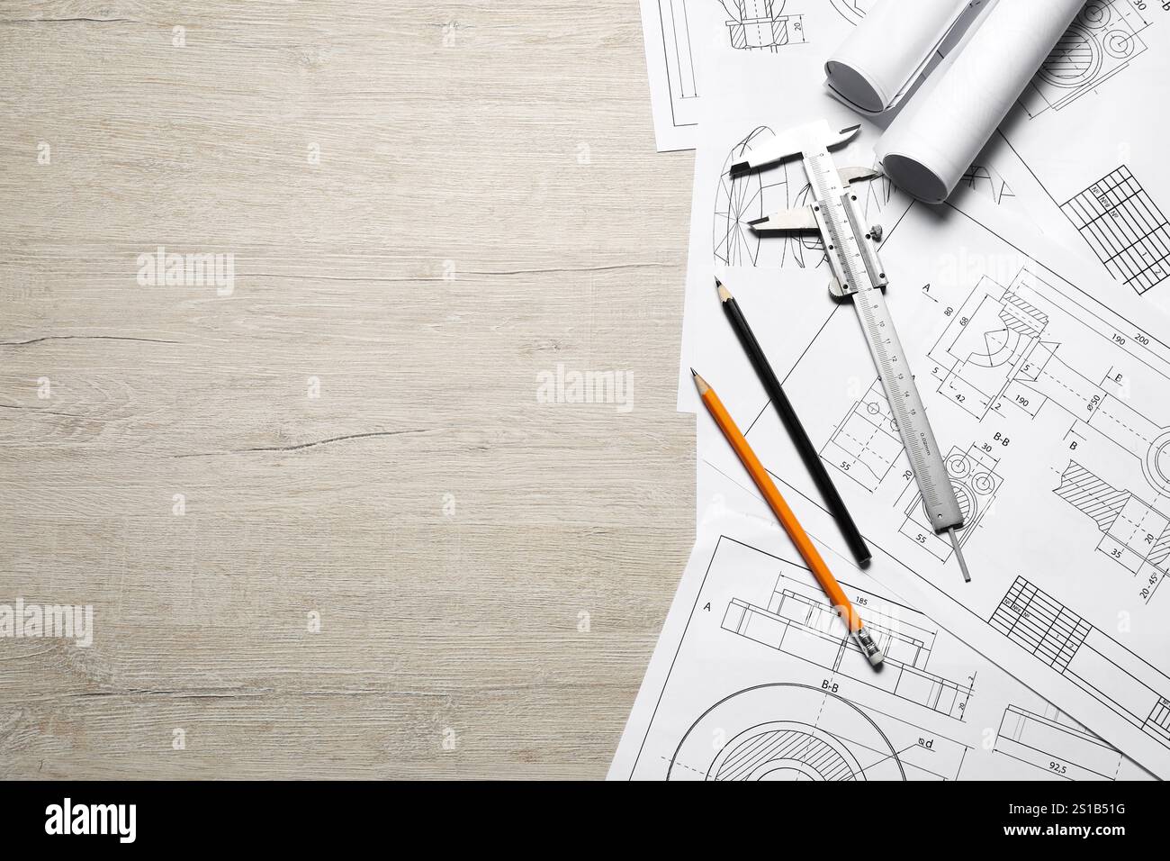 Different engineering drawings, vernier caliper and pencils on wooden ...