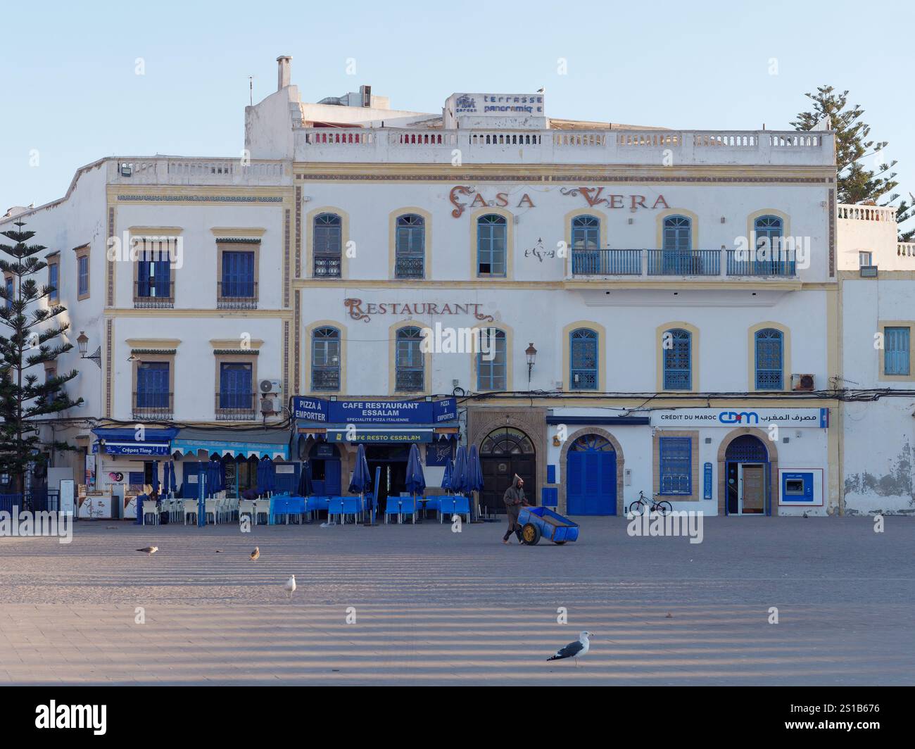Local man pushes a cart for transporting goods in an empty piazza with ...