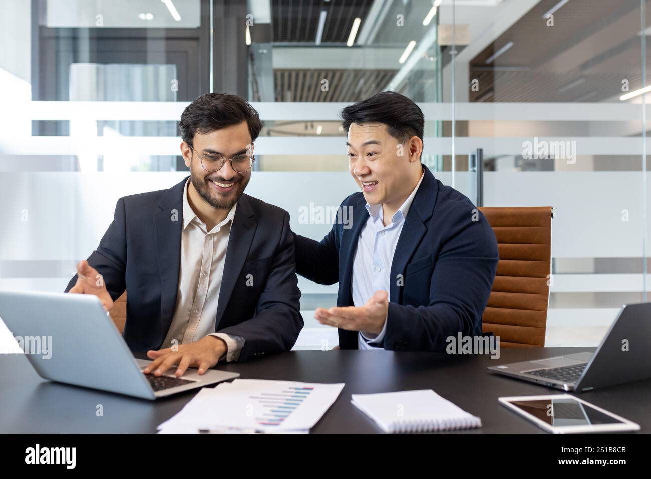 Male mentor at workplace helping intern learn new work project, two men ...