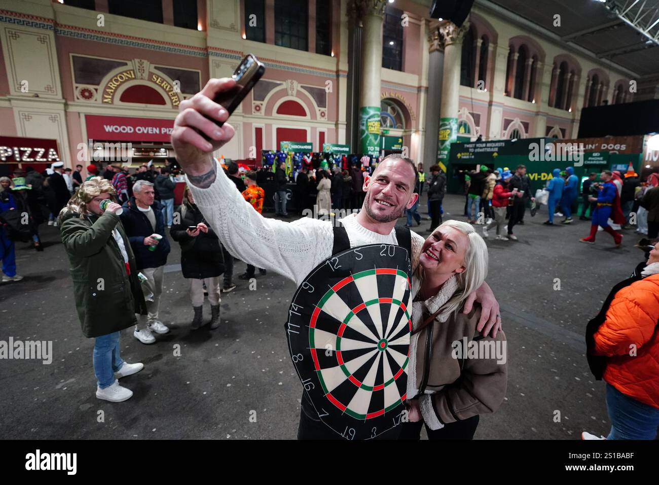 Darts fans in fancy dress pose for a photo during day fifteen of the ...