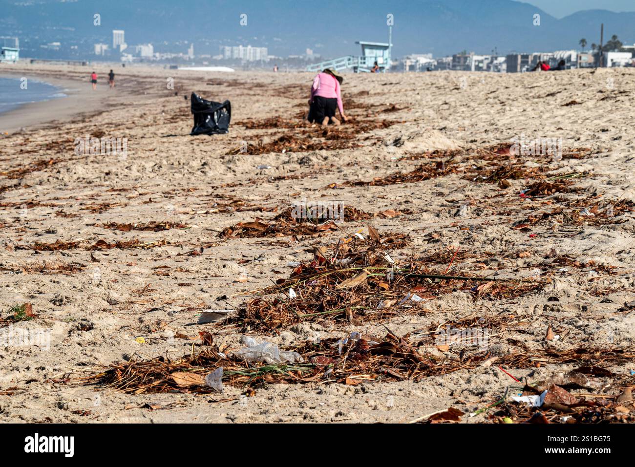 A couple of local residents cleanup trash and plastic on beach in Playa ...