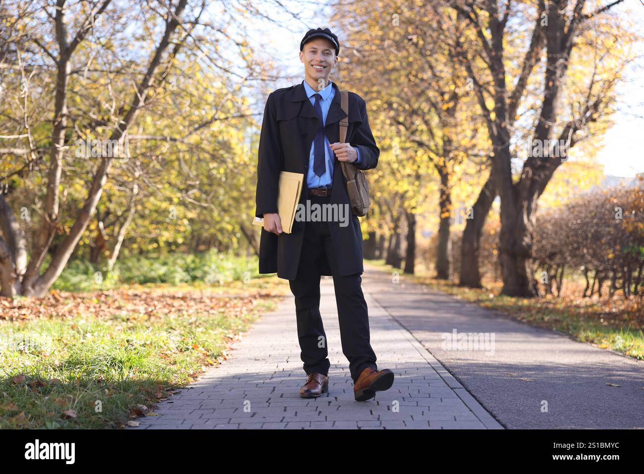 Happy postman with bag and envelopes outdoors Stock Photo - Alamy