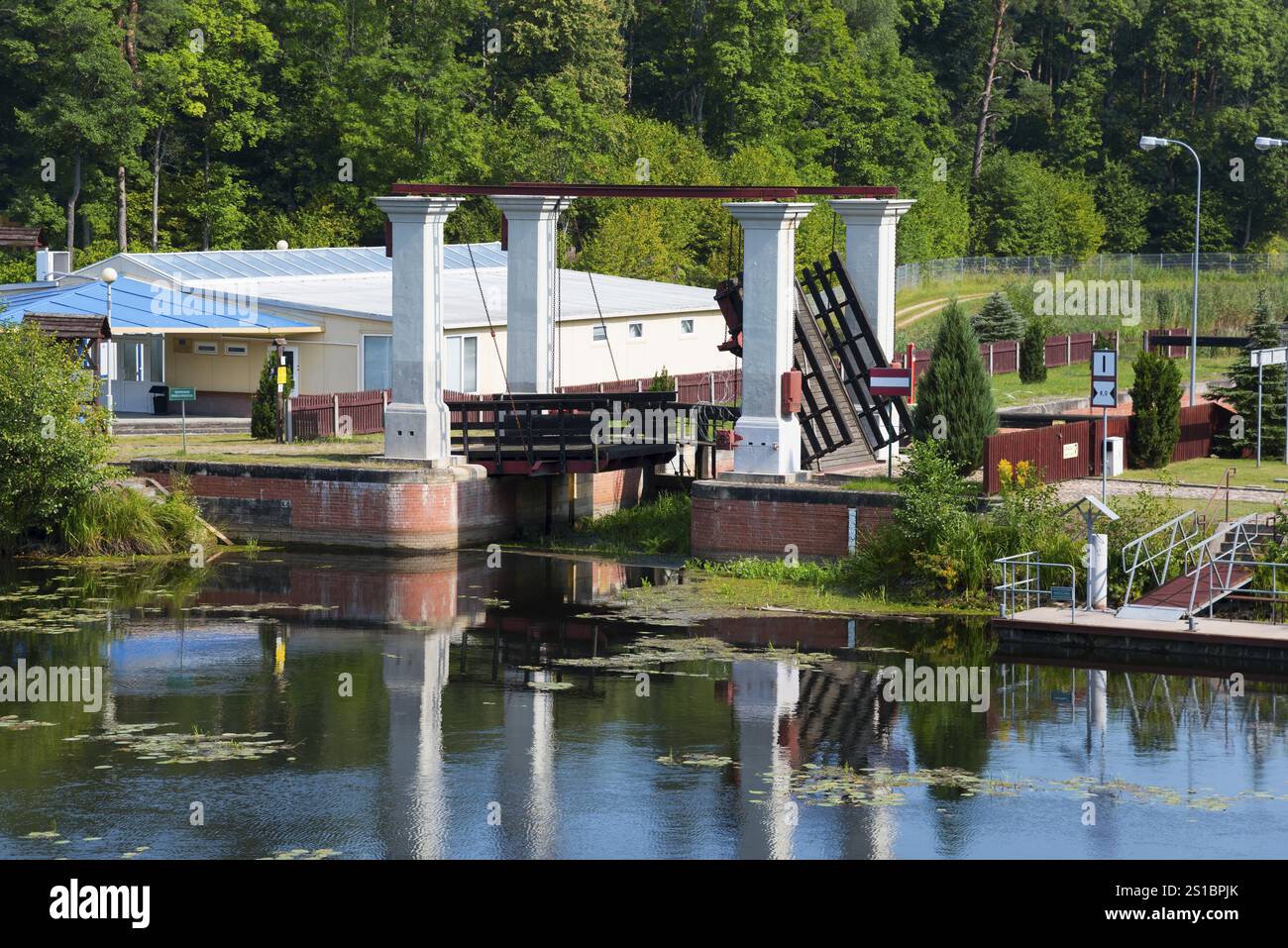 Lock bridge with neighbouring building in the countryside on a summer's ...