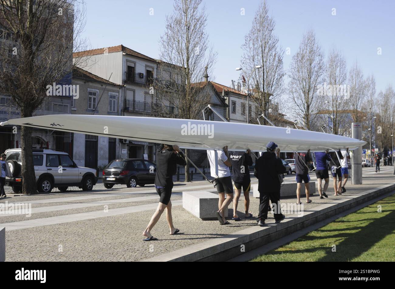 Team working together to bring a rowing boat to the water, Douro River ...