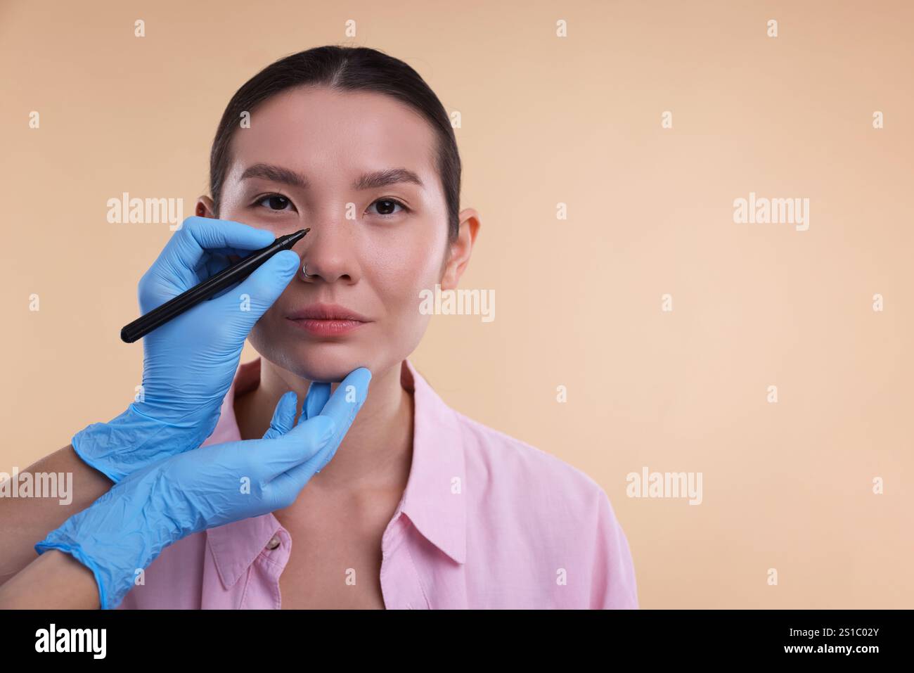 Doctor drawing marks on patient's nose for plastic surgery operation ...