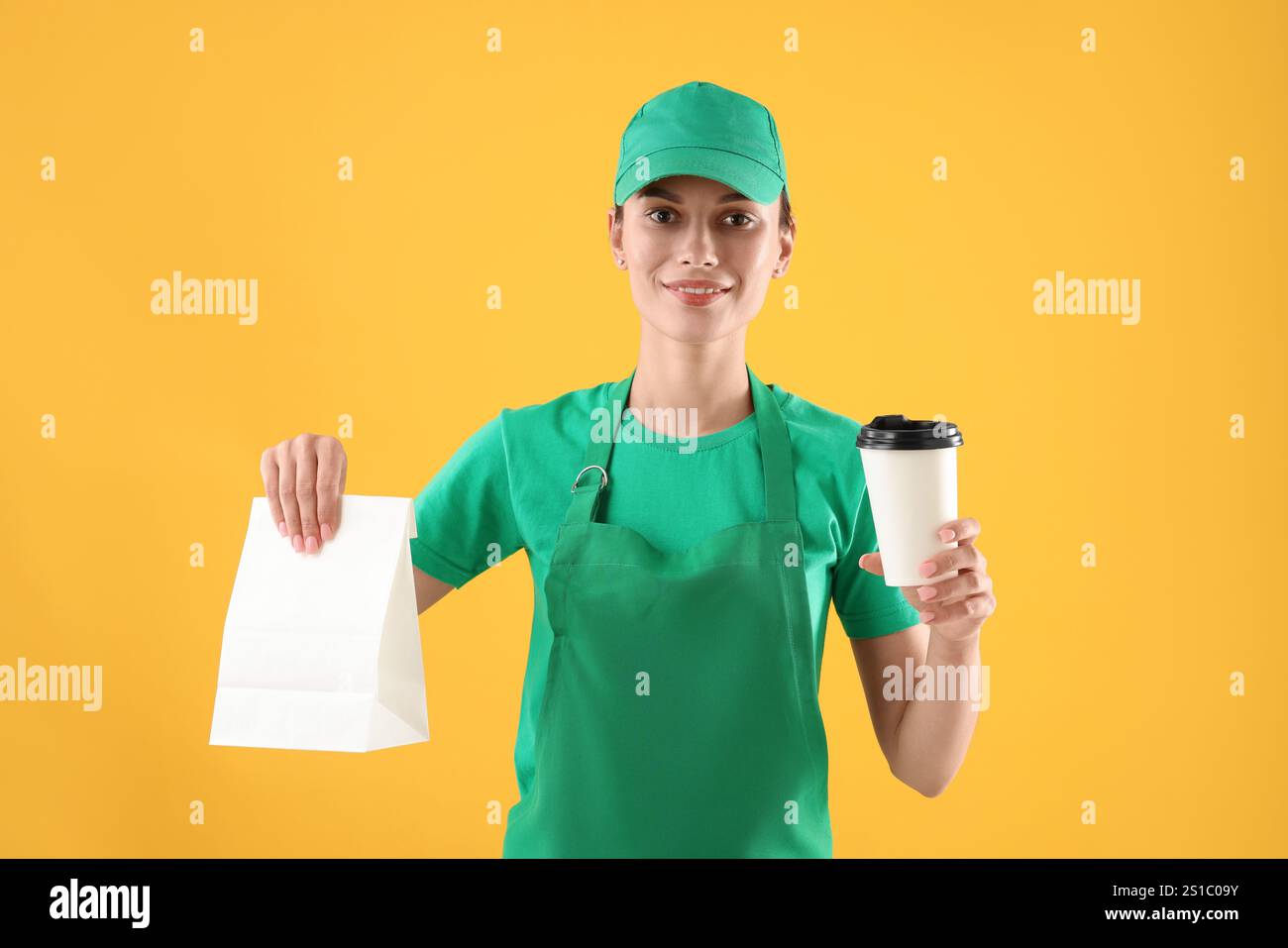 Fast-food worker with paper bag and cup on orange background Stock ...