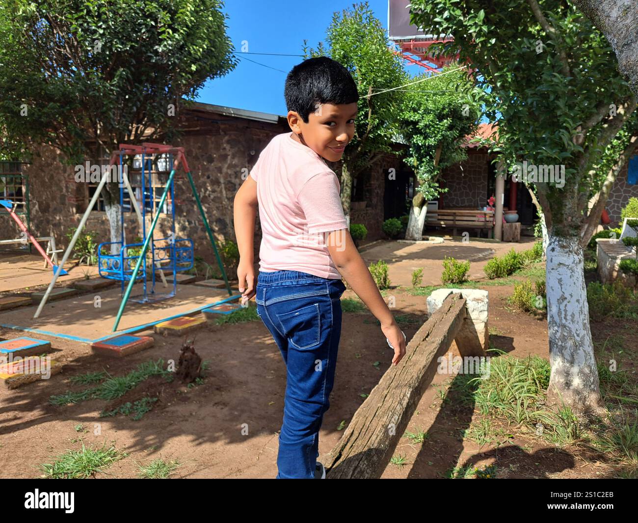 9-year-old dark-skinned Latino male child practices balance exercises ...