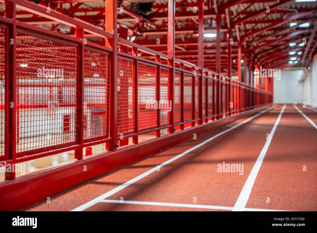 Close-up photo of the red railing along an elevated indoor running ...