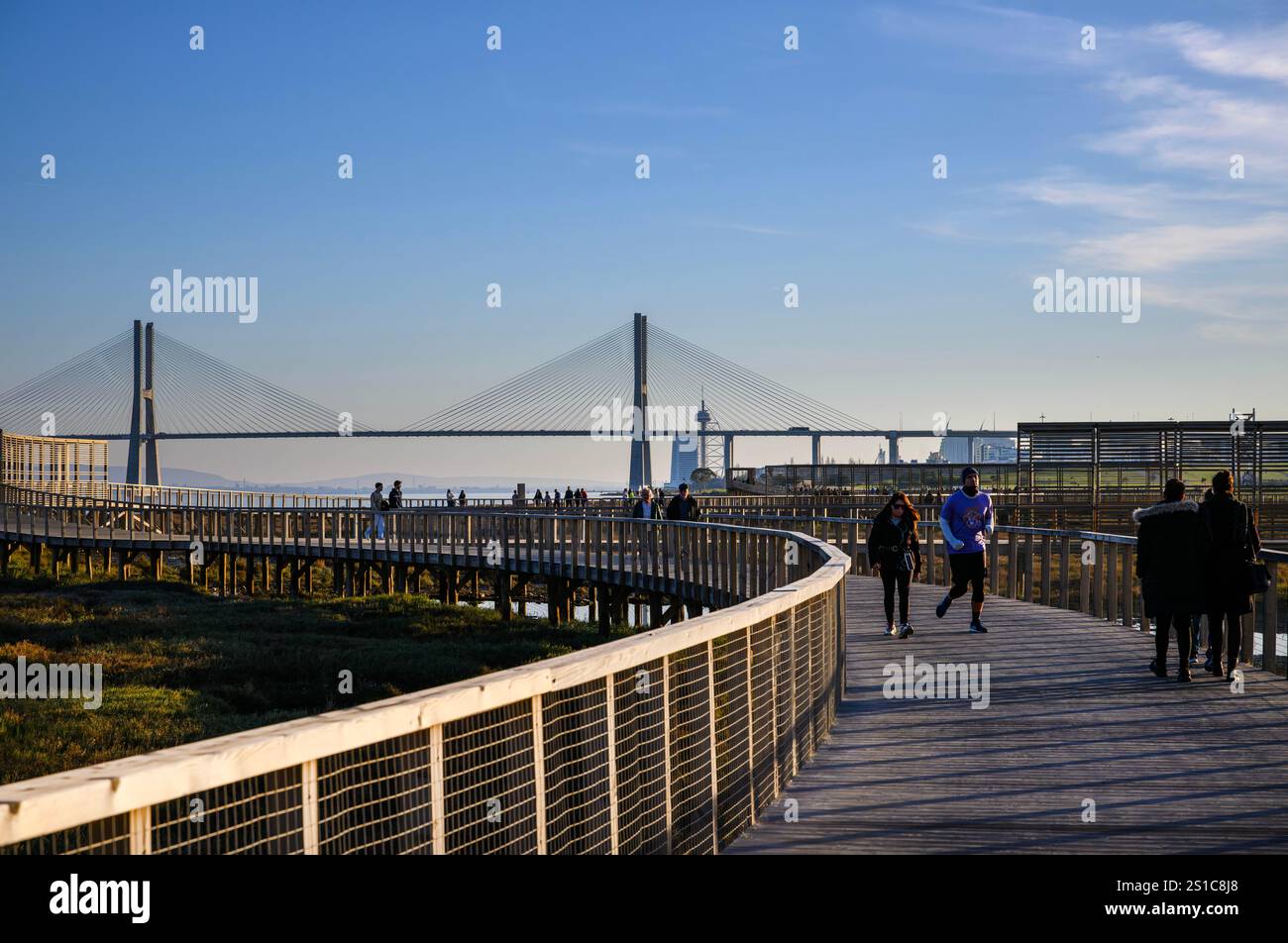 People are seen walking along the footpath of Riberinho de Loures ...