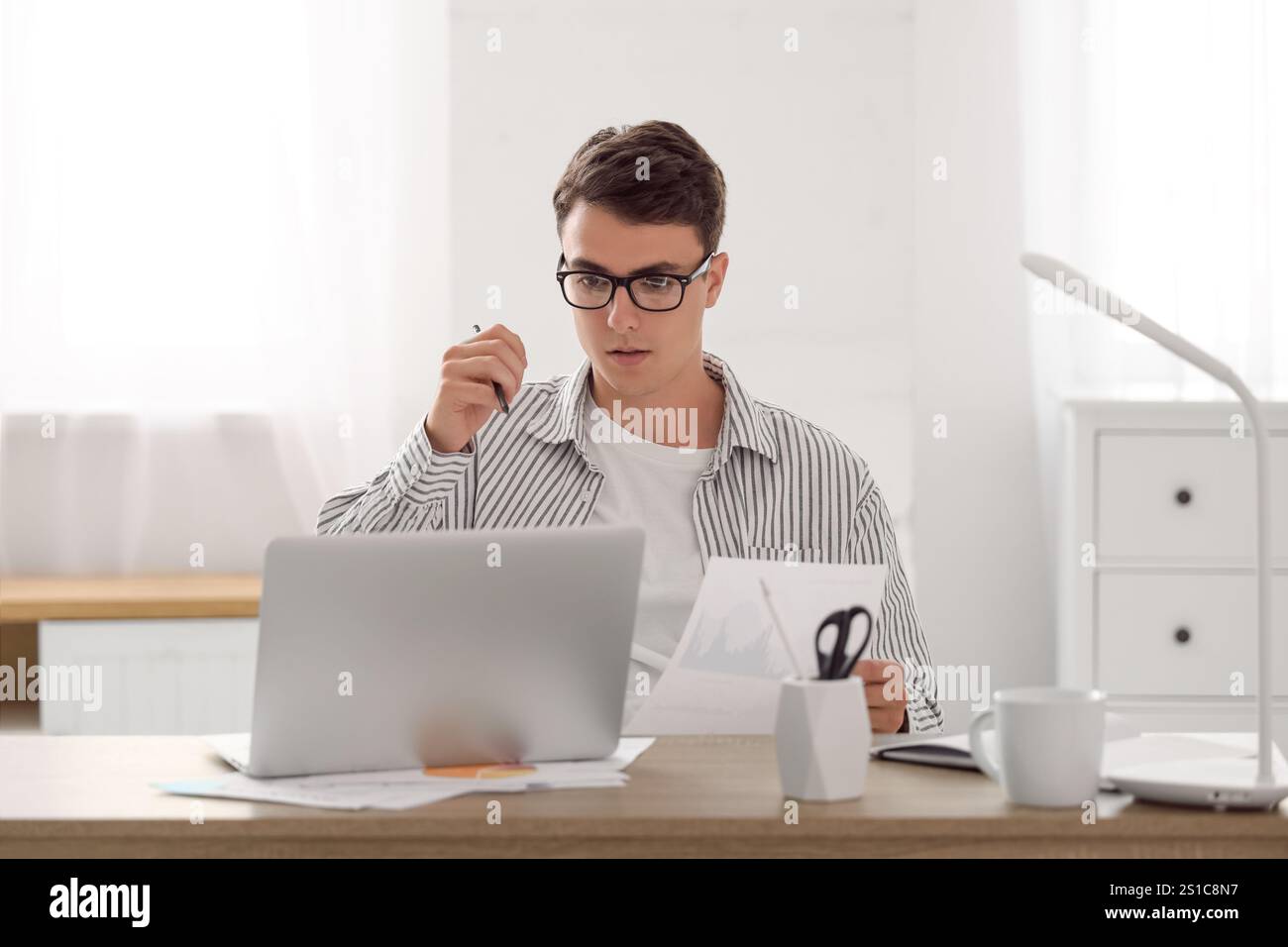 Male economist working with diagrams at table in office Stock Photo - Alamy