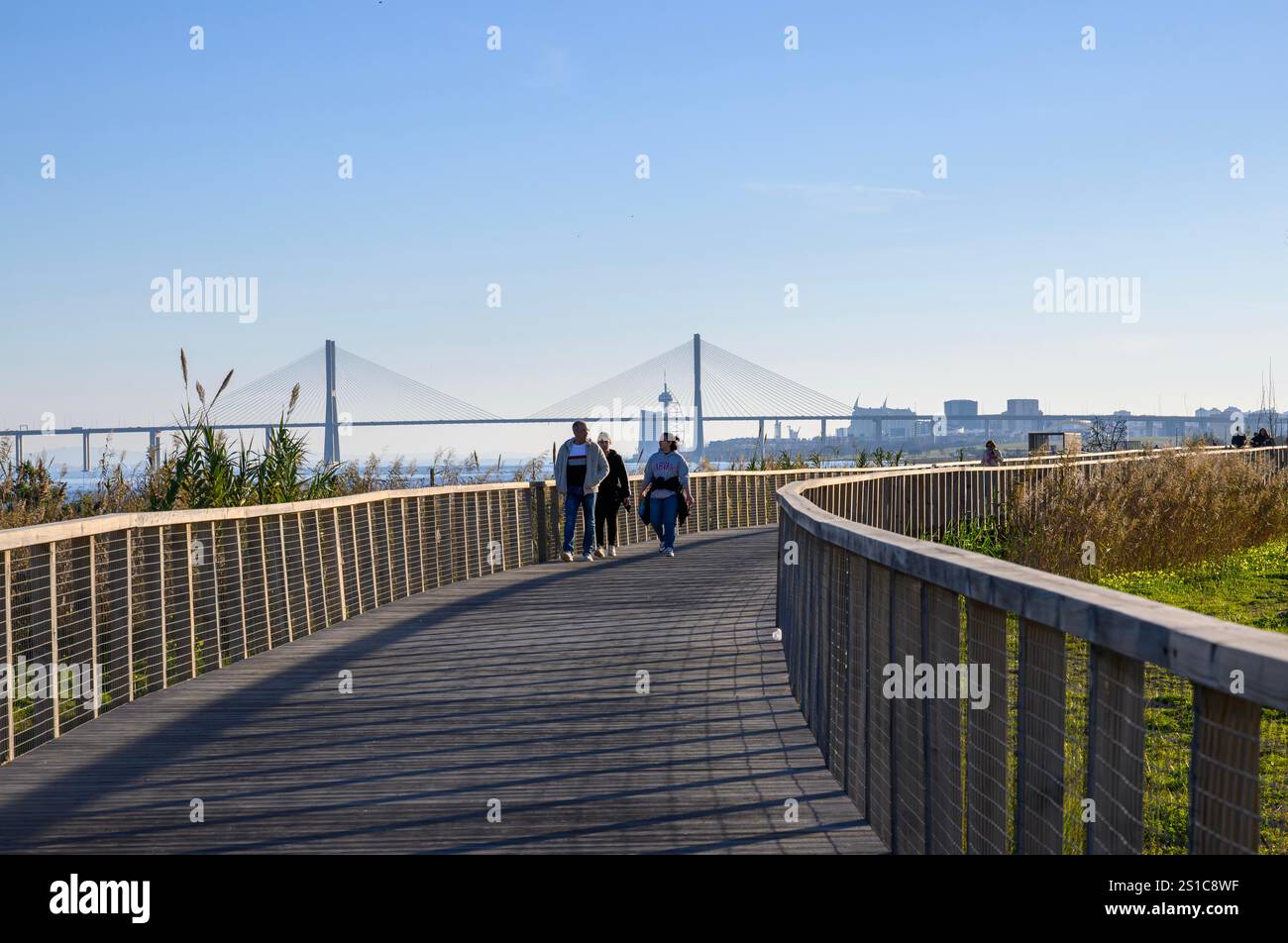 People are seen walking along the footpath of Riberinho de Loures ...