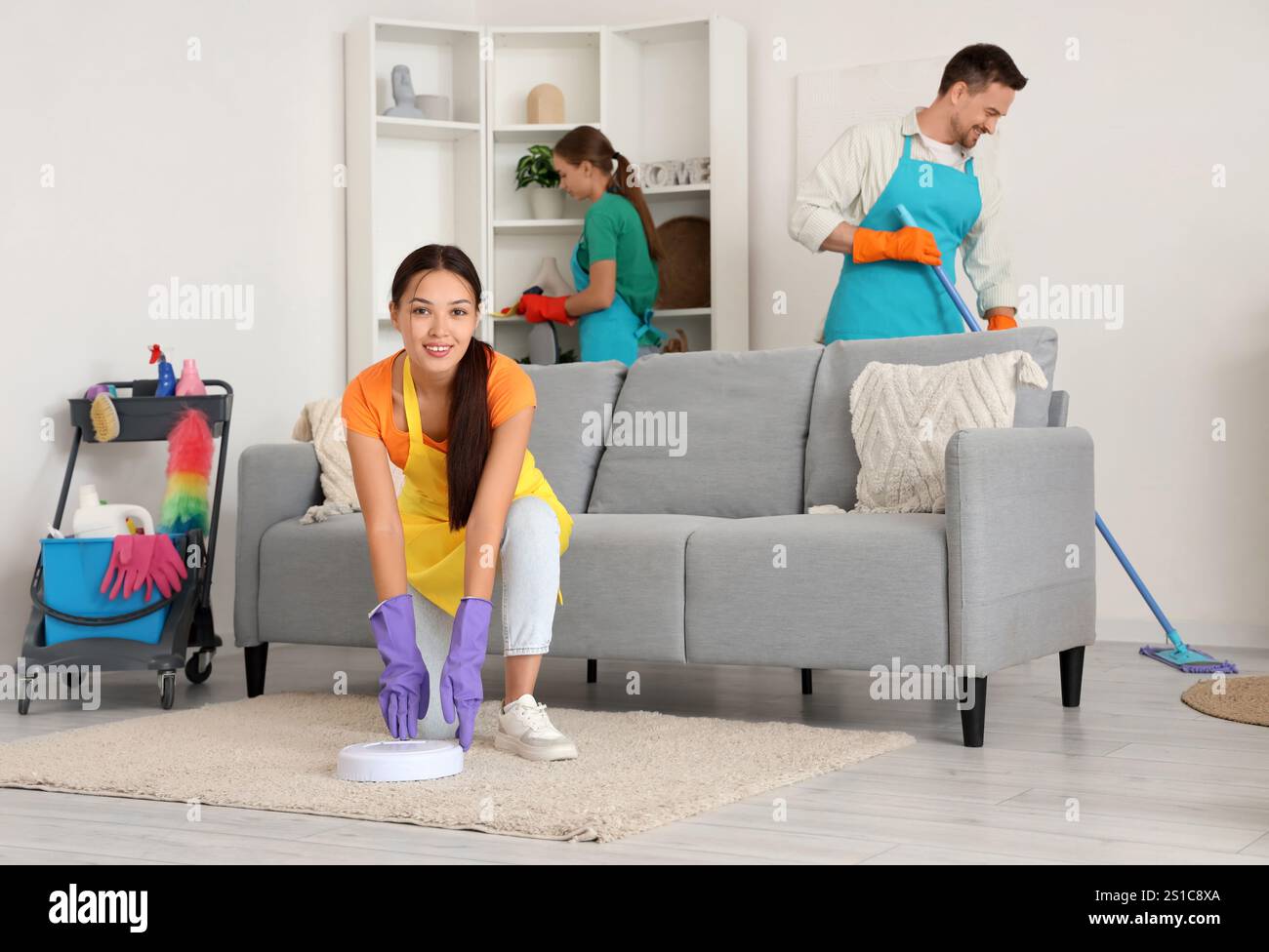 Female Asian janitor with robot vacuum cleaner in room Stock Photo - Alamy