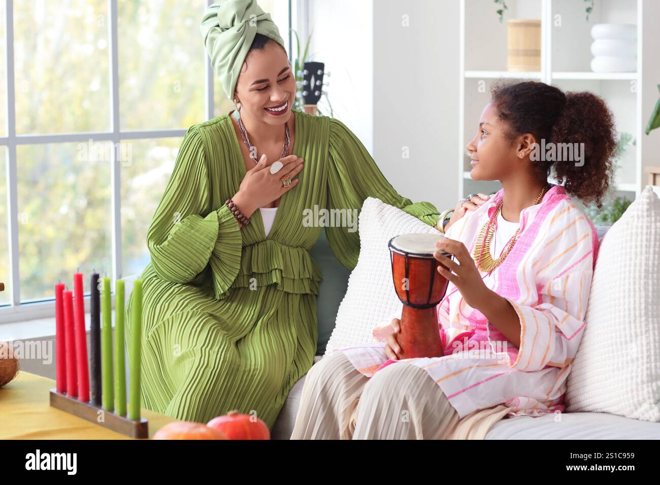 African-American girl with tam-tam drum and her mother celebrating ...