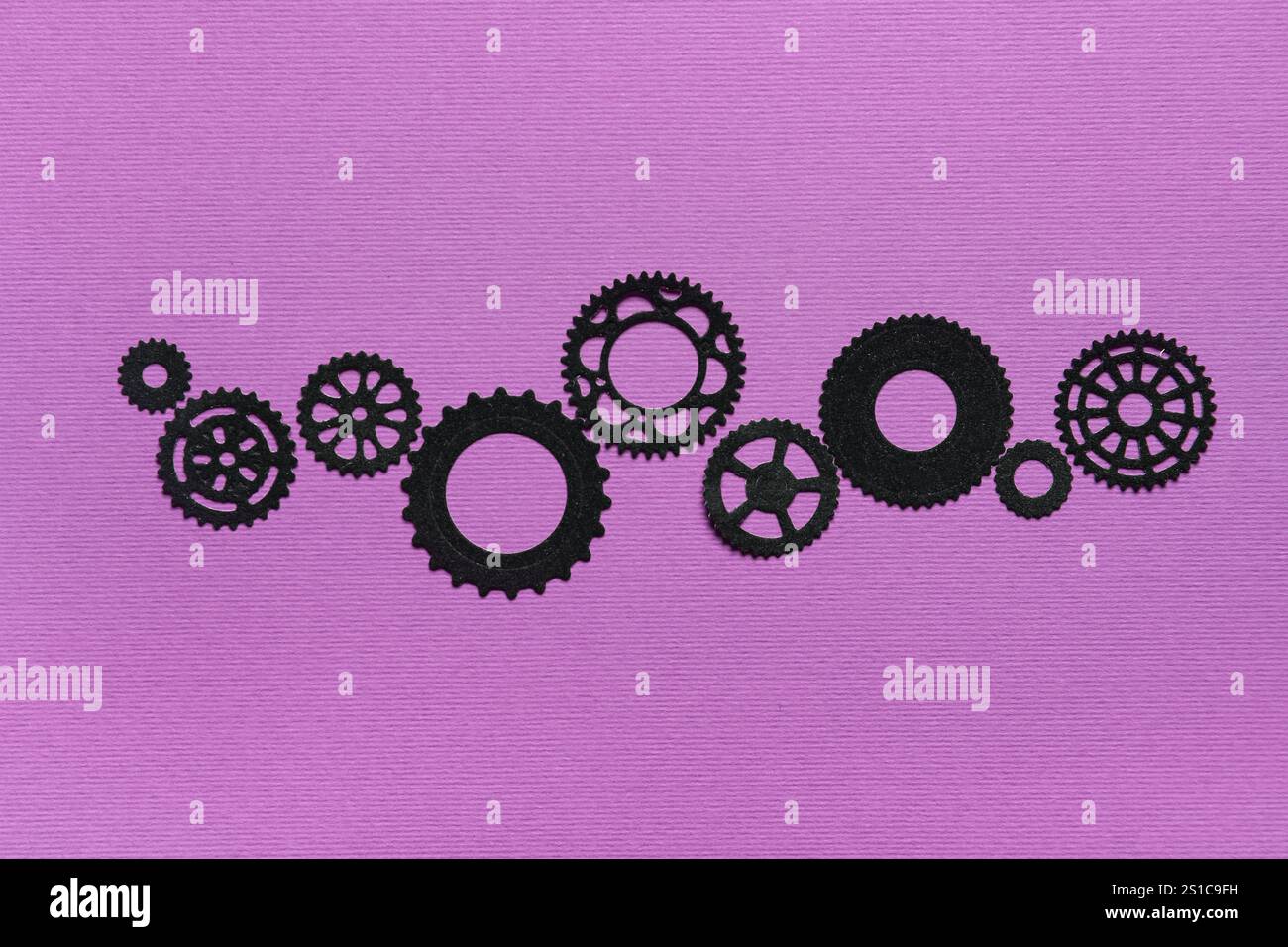 Black paper gears on purple background Stock Photo - Alamy