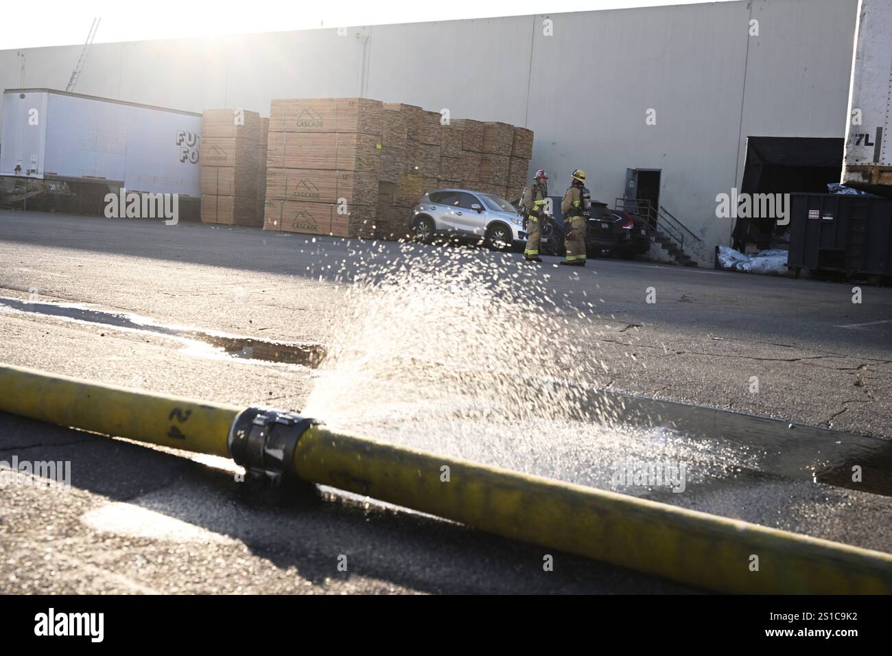 Firefighters stage outside a building where a plane crash occurred ...