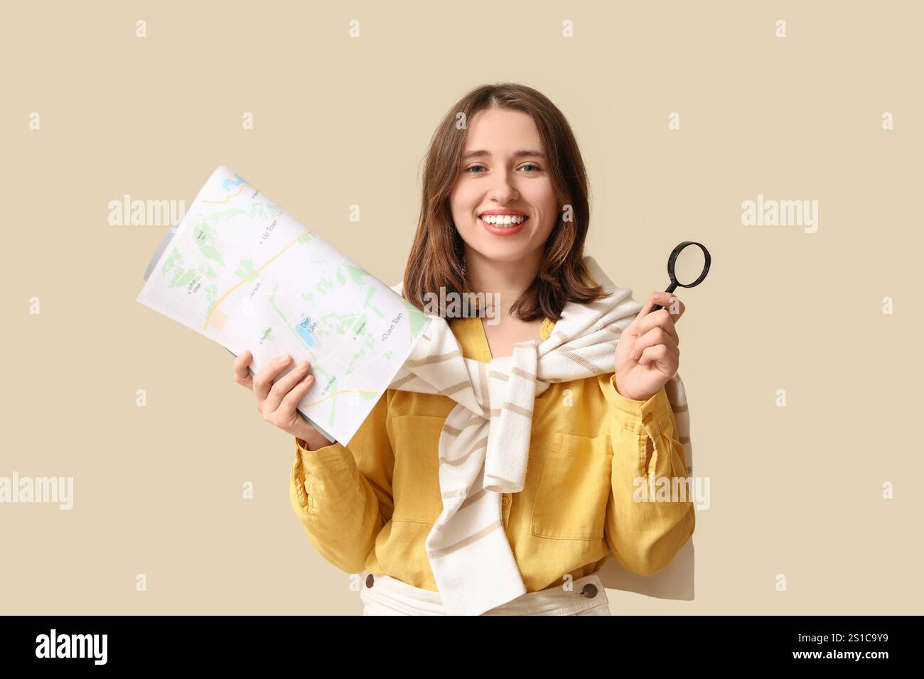 Female traveler with map and magnifier on beige background. Itinerary ...