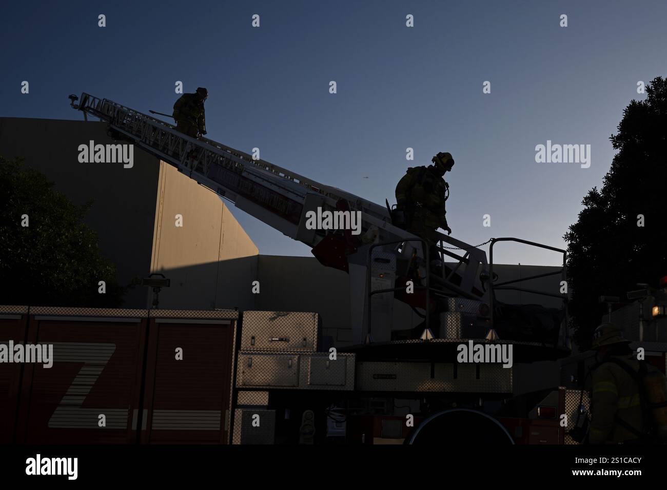 Firefighter walk down a ladder outside a building where a plane crash ...