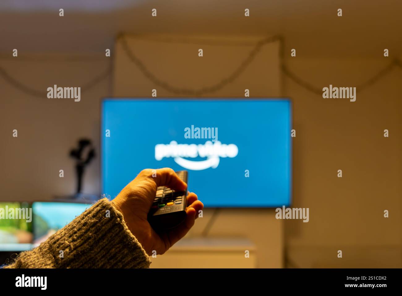 Hand holding remote control pointing at a smart tv streaming platform ...